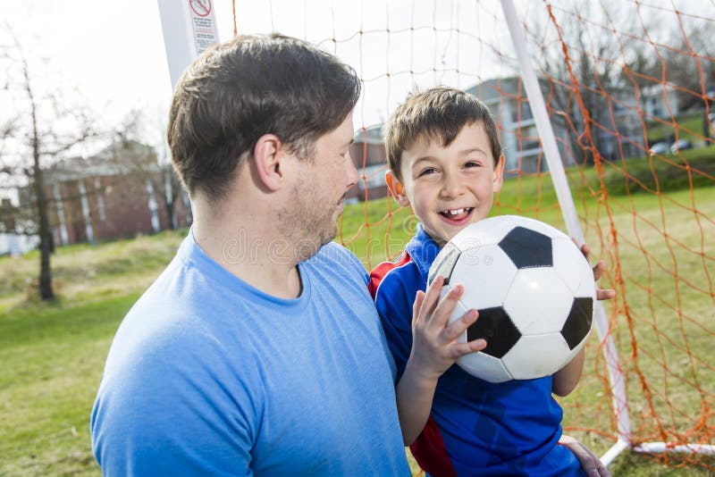 Man with Child Playing Football on Pitch Stock Photo - Image of child ...