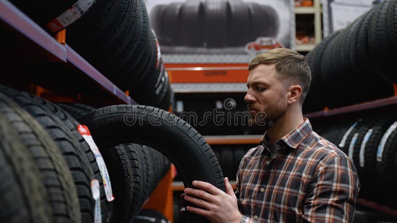 A Man Choose New Tire for Car at Auto Parts Store. Concept of Choosing ...