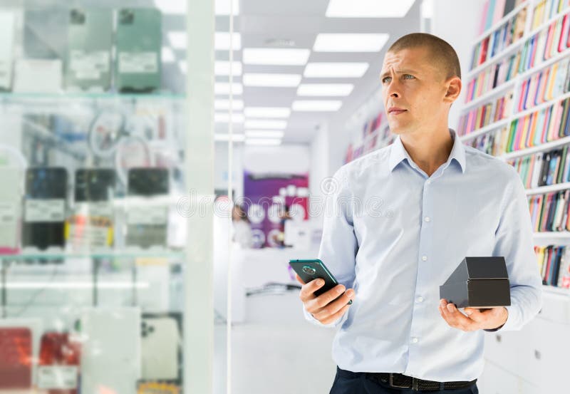 Man Chooses Mobile Phone in Electronics Store Stock Image - Image of ...