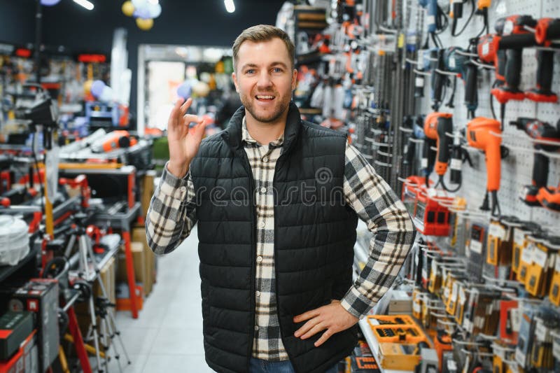 A Man Chooses a Power Tool in a Hardware Store Stock Photo - Image of ...