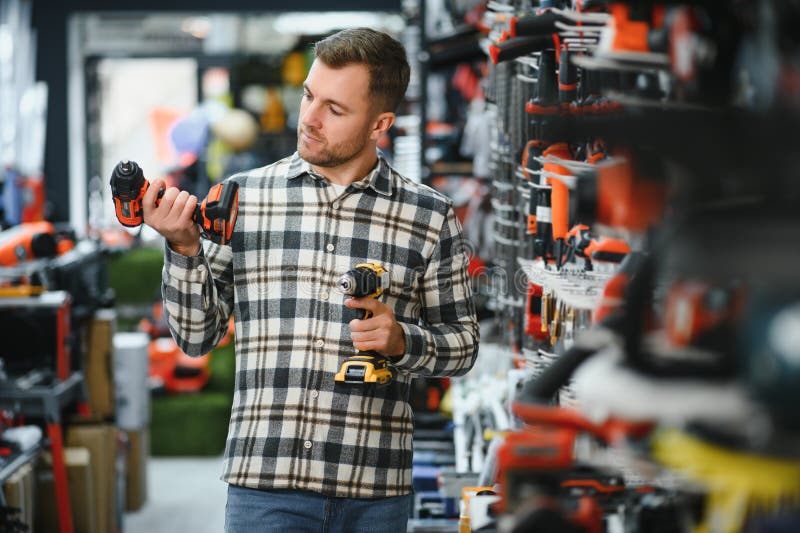A Man Chooses a Power Tool in a Hardware Store Stock Photo - Image of ...