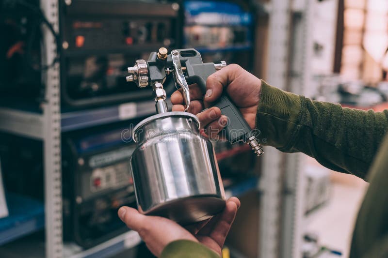 A Man Chooses a Spray Gun at a Hardware Store Stock Image - Image of ...