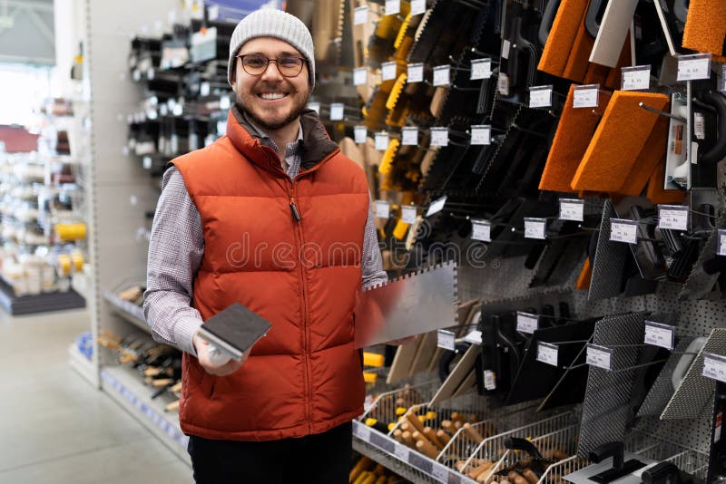 A Man Chooses Tools for Puttying and Plastering Walls in a Hardware ...