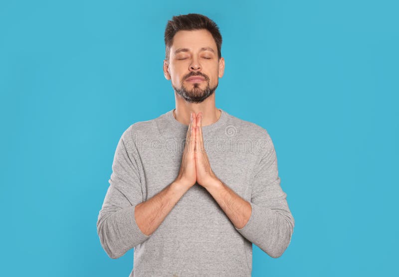 Man with Clasped Hands Praying on Turquoise Background Stock Photo ...