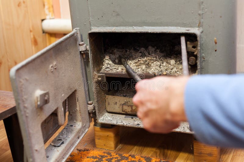 Man Clean Burn Wood Coals of Fire in Solid Bio Fuel Boiler. Stock Image ...