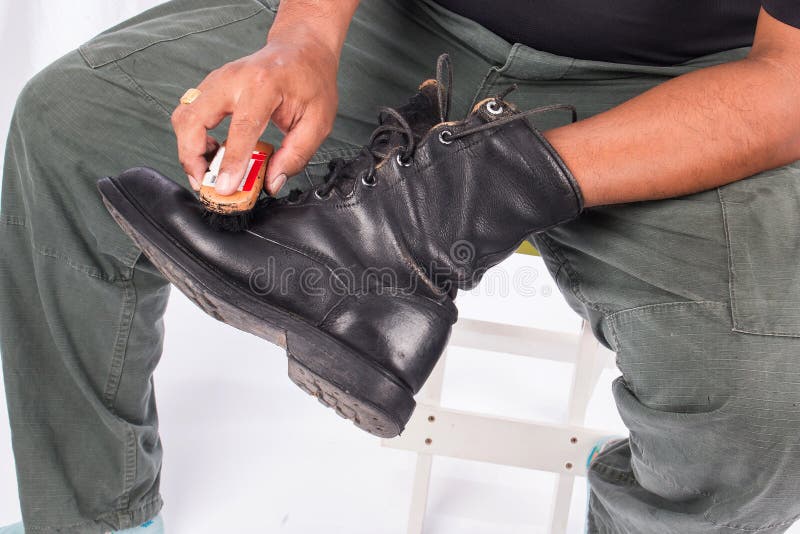 Man cleaning combat shoes stock image. Image of human - 73898169