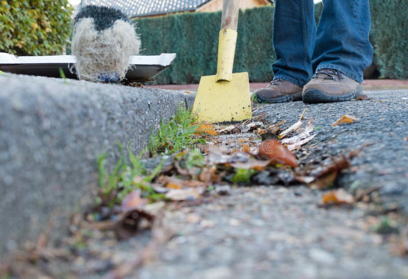Man is cleaning the gutter stock image. Image of curbstone - 130744467