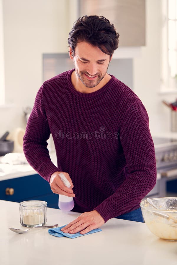 Man Cleaning Kitchen Counter with Spray and Cloth after Cake Baking ...