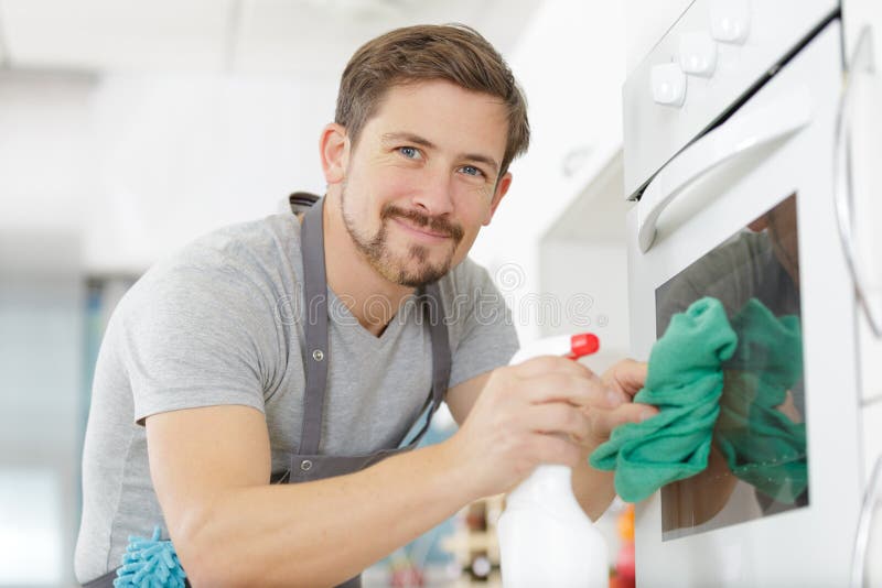 Man cleaning oven stock image. Image of service, springcleaning - 260650295