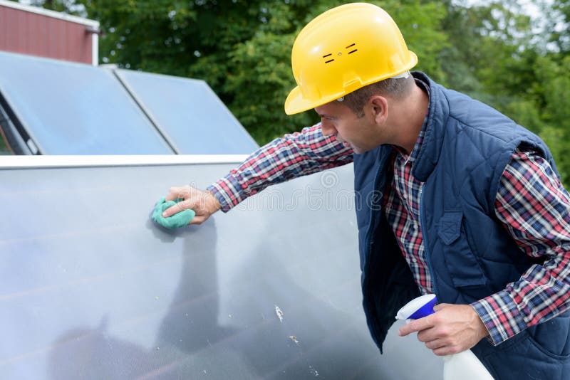 Man cleaning solar panels stock image. Image of generation - 264498401