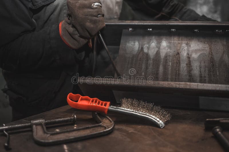 Man Cleans Welding Seams. Worker Processes a Piece of Iron Stock Photo ...