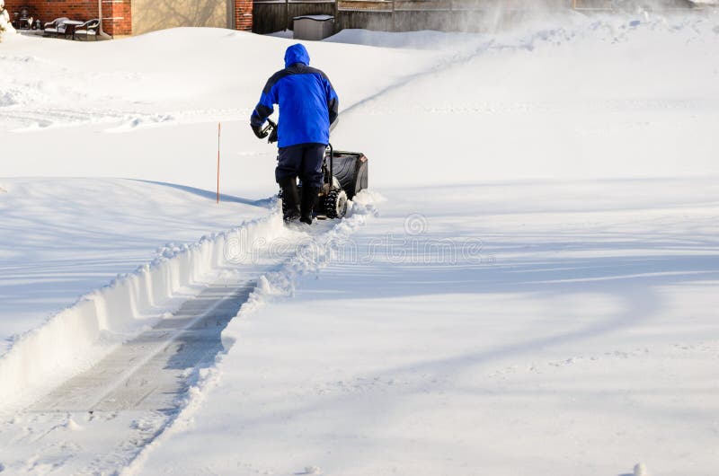 Man Clearing a Path Using a Snow Blower To Clear a Residential Driveway ...