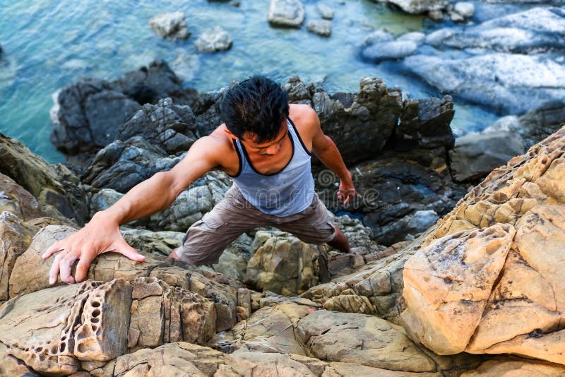Man Climbing the Rocks Near the Sea. Stock Image - Image of nature ...