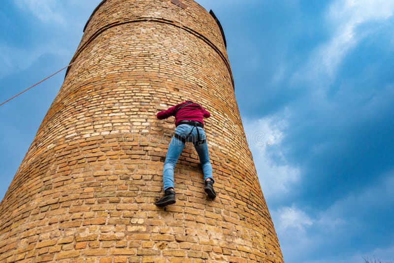 A Man Climbs Up a Tower with a Rope Stock Image - Image of ...