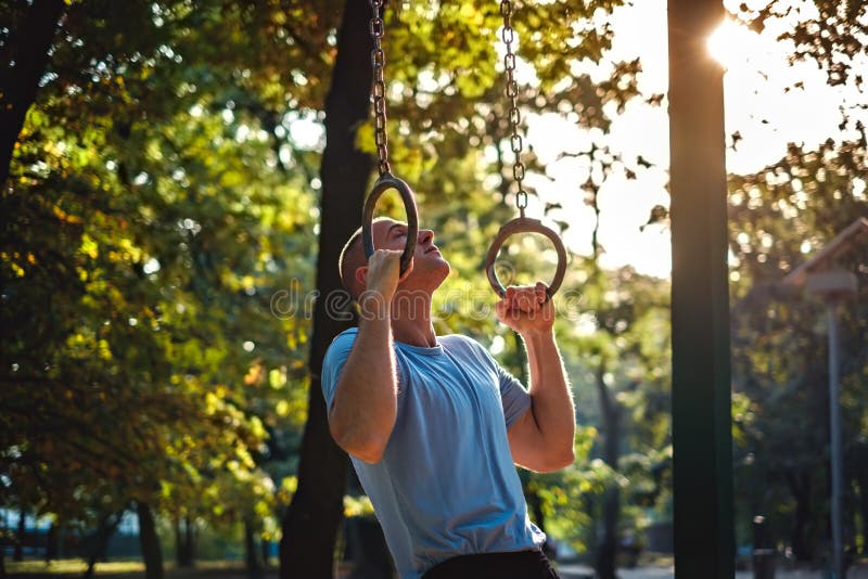 Man with Closed Eyes Hanging on Rings in the Park Stock Image - Image ...