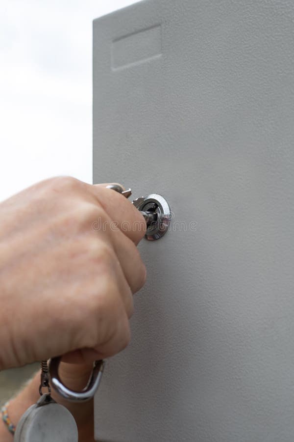 A Man Closes the Lock on the Electrical Panel Cover. Security of Power ...