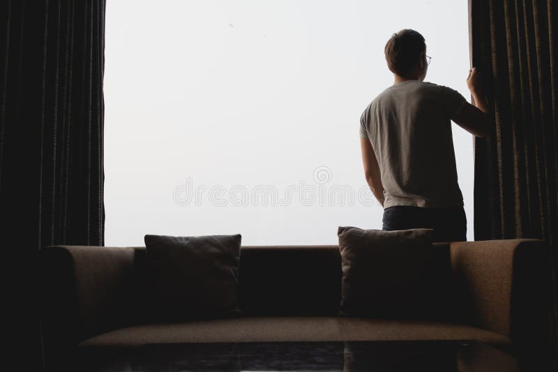 Man Closing the Curtain while Watching the View Out of the Window ...