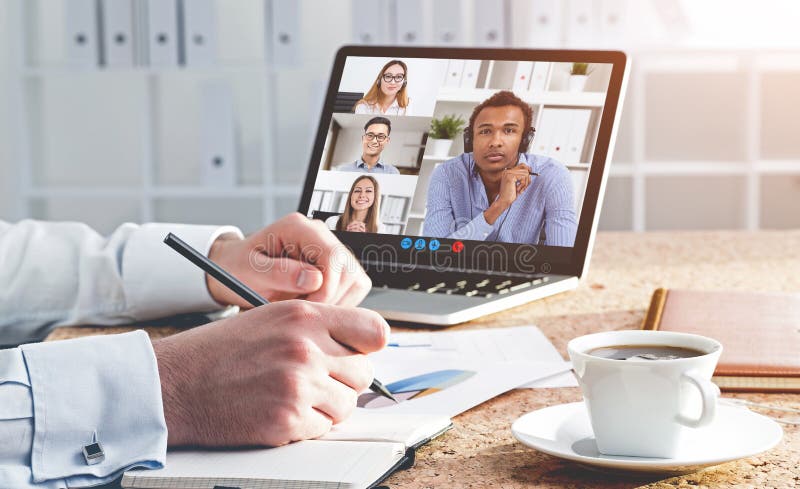 Man with Coffee Taking Notes during His Video Chat with Colleagues ...