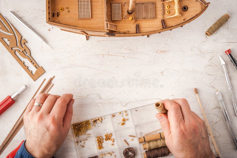 Man Collects Ship Model on a White Table Stock Photo - Image of frame ...