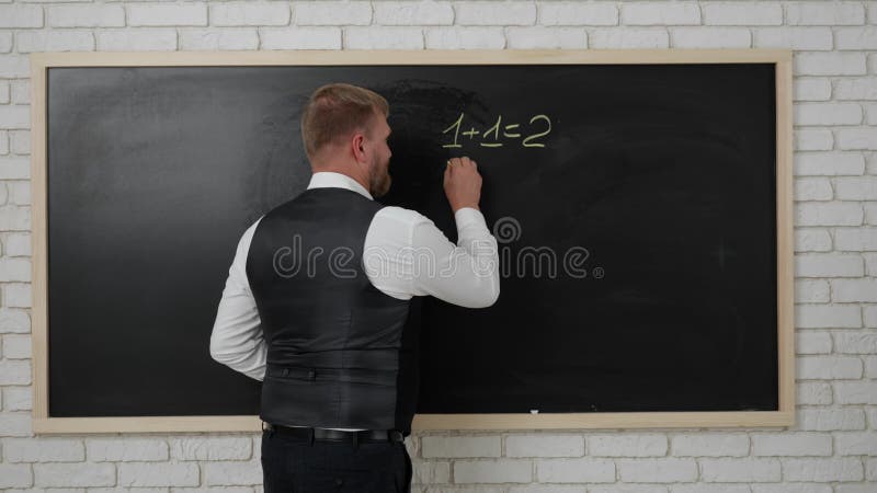 Man College Teacher in Classroom in Front of Chalkboard Explaining ...