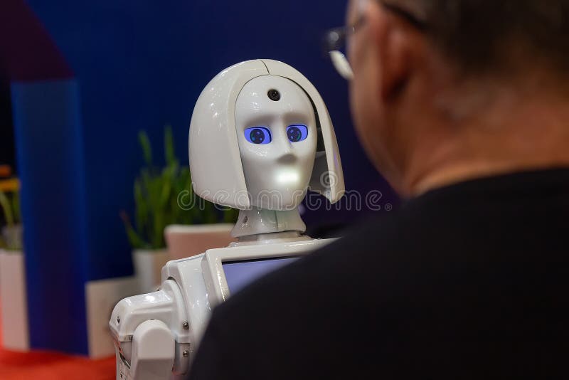 A Humanoid Robot with a Sleek, White and Black Design Interacts with a ...
