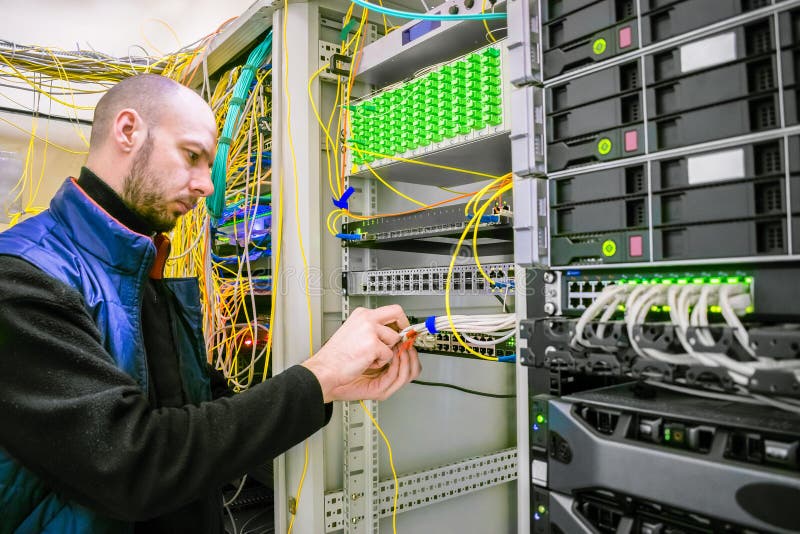 A Man Commutes Internet Wires in a Server Rack. the System ...