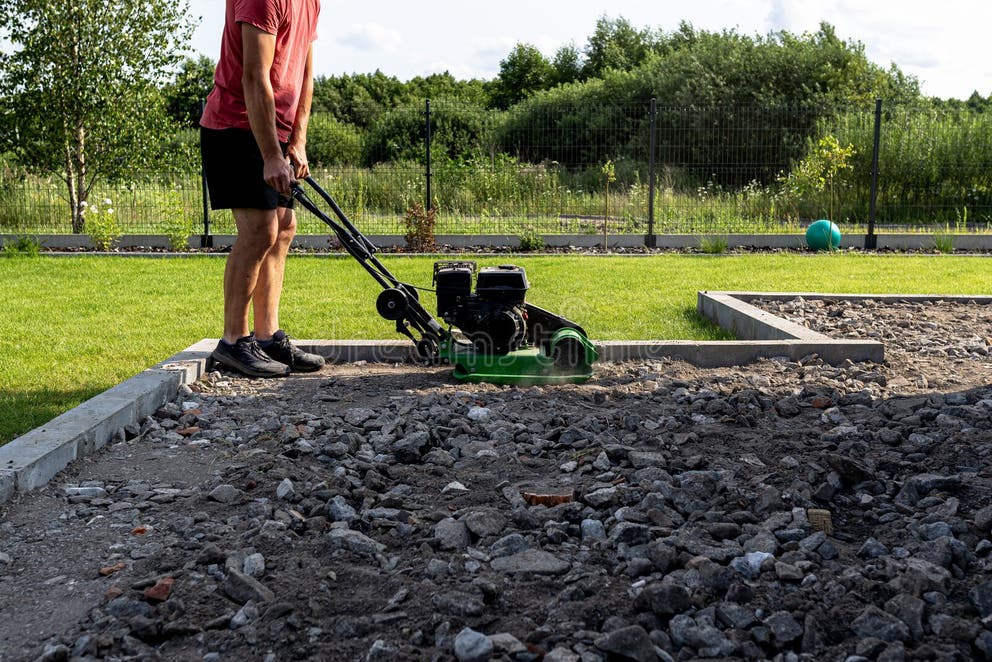 A Man Compacts Rubble on a Terrace Under Construction Using a Hand-held ...