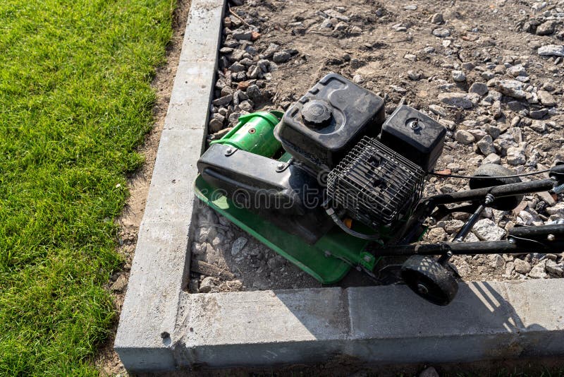 A Man Compacts Rubble on a Terrace Under Construction Using a Hand-held ...