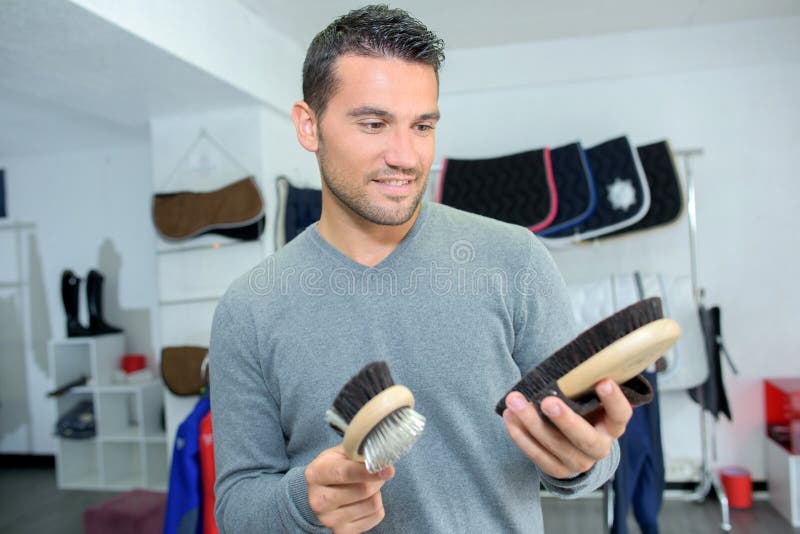 Man Comparing Horse Brushes Stock Image - Image of evaluate, commerce ...
