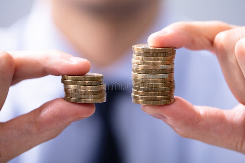 Man Comparing Two Coin Stacks Stock Photo - Image of salary, disparity ...