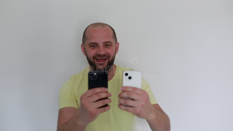 Man Comparing Two Smartphones Against White Background in Daylight ...
