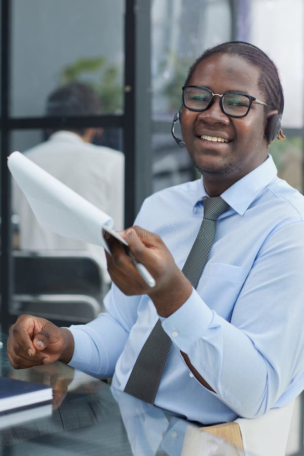 A Man at a Computer in a Call Center Talking Using Headphones with a ...