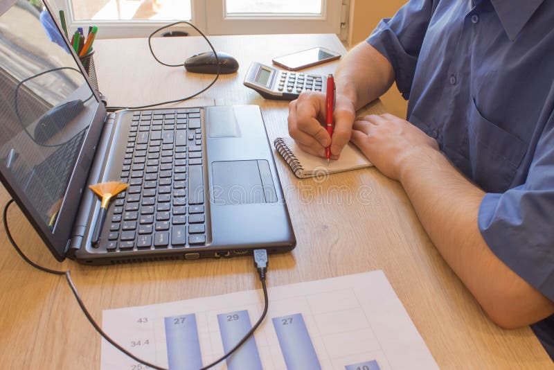The Man and Computer are Using a Calculator on the Table in the Office ...