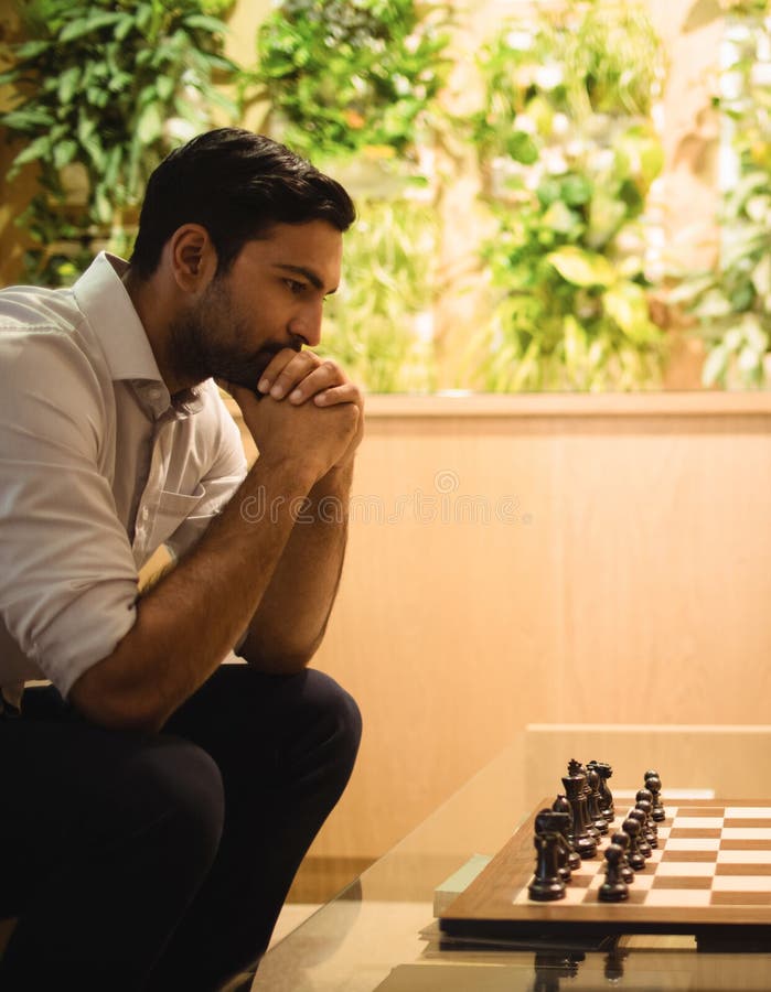 Man Concentrating on Chess Game in Modern Office with Green Plants ...