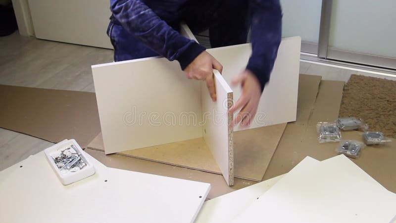 A Man Connects the Panels with an Eccentric. Wooden Modular Rack ...