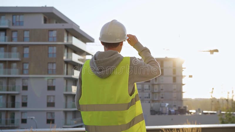 Man Constructive Engineer with White Hard Hat and Safety Vest is Using ...