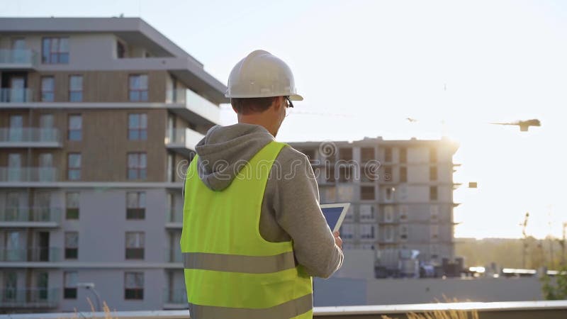 Man Constructive Engineer with White Hard Hat and Safety Vest is Using ...