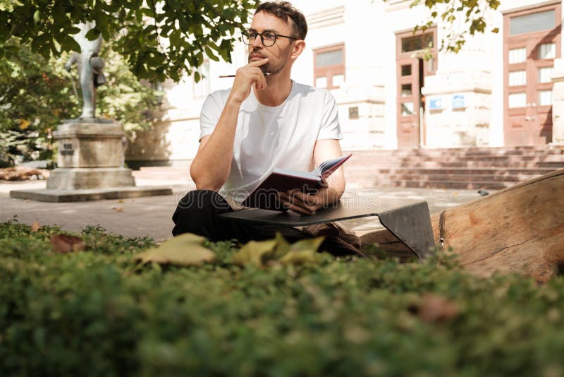 Man Contemplating Ideas while Sitting Outside with Notebook Stock Image ...