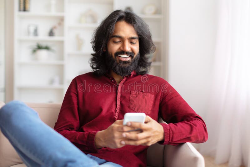 Man Contently Texting on Smartphone at Home Stock Photo - Image of ...