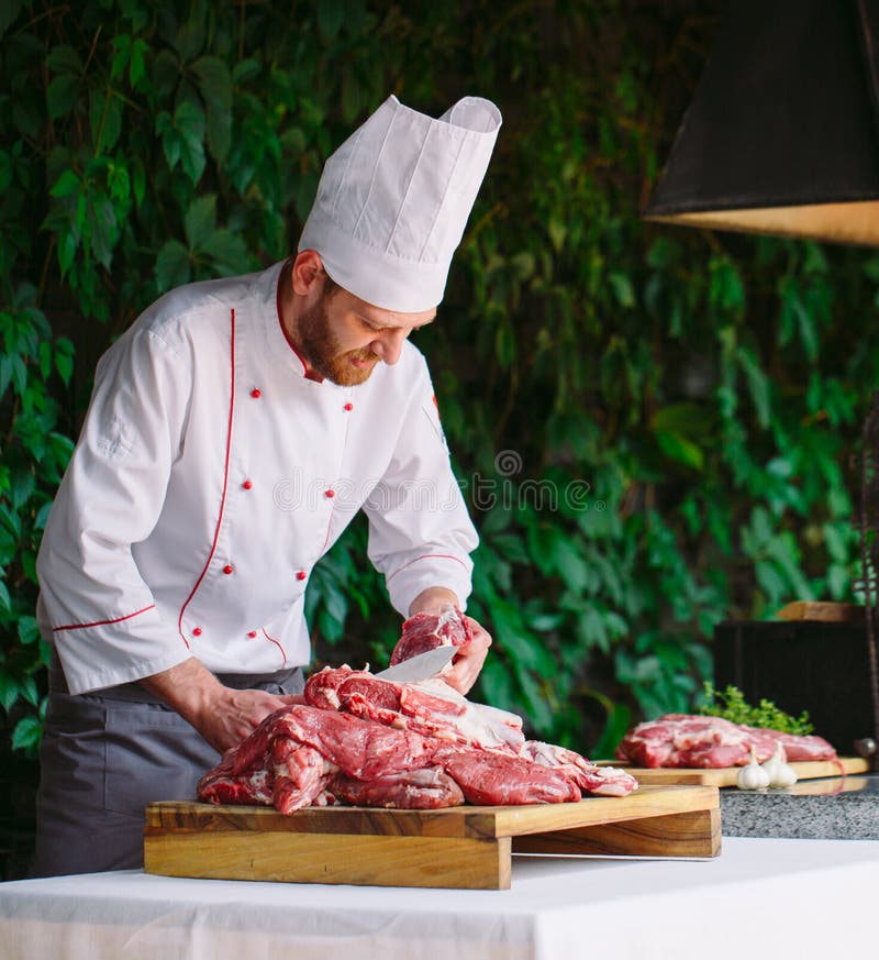 A Man Cook Cuts Meat with a Knife in a Restaurant Stock Image - Image ...