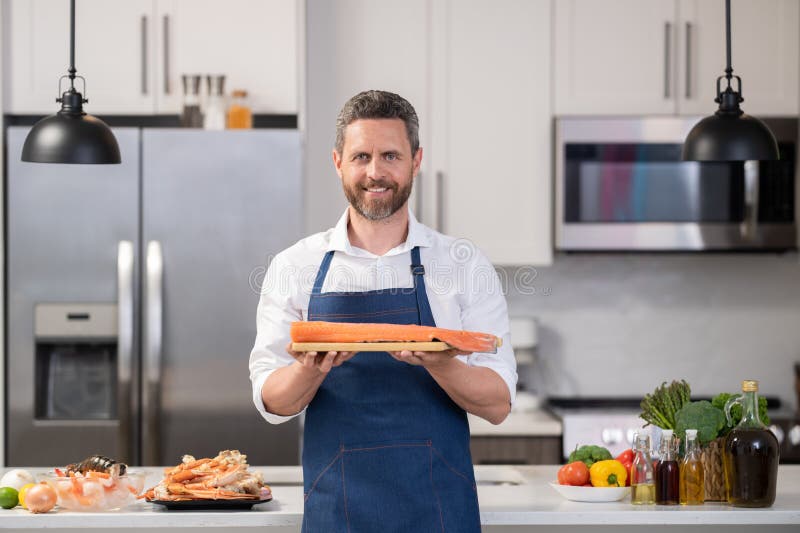 Man Cook Delicacy Salmon Fish. Man Cook Delicacy Salmon in the Kitchen ...