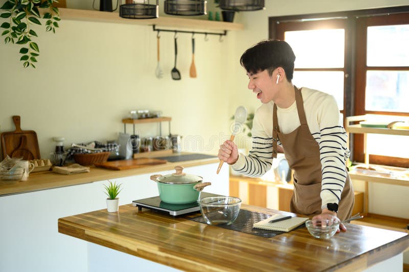 Man Cook Singing into Spoon Like Microphone while Preparing Food in ...