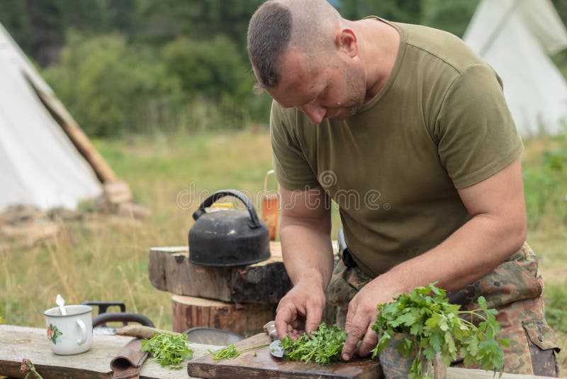 Man Cooking Meat Over Bonfire at Campsite Editorial Image - Image of ...
