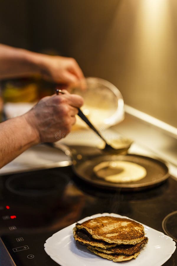 Man cooking pancakes stock photo. Image of hands, domestic - 110919928