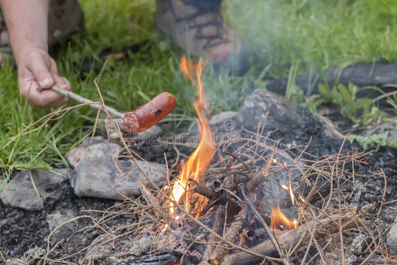 Man cooking a sausage stock image. Image of baked, fire - 55787633