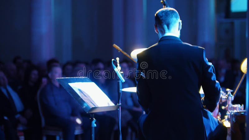 A Man in Costume Playing Drums and Looking at Notes at the Jazz Concert ...