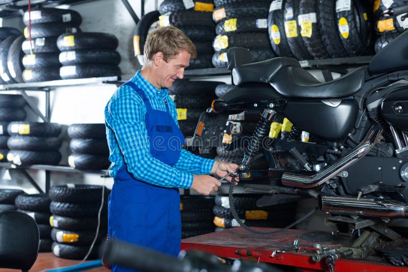 Man in Coveralls Checking Motorcycle Stock Photo - Image of retail ...