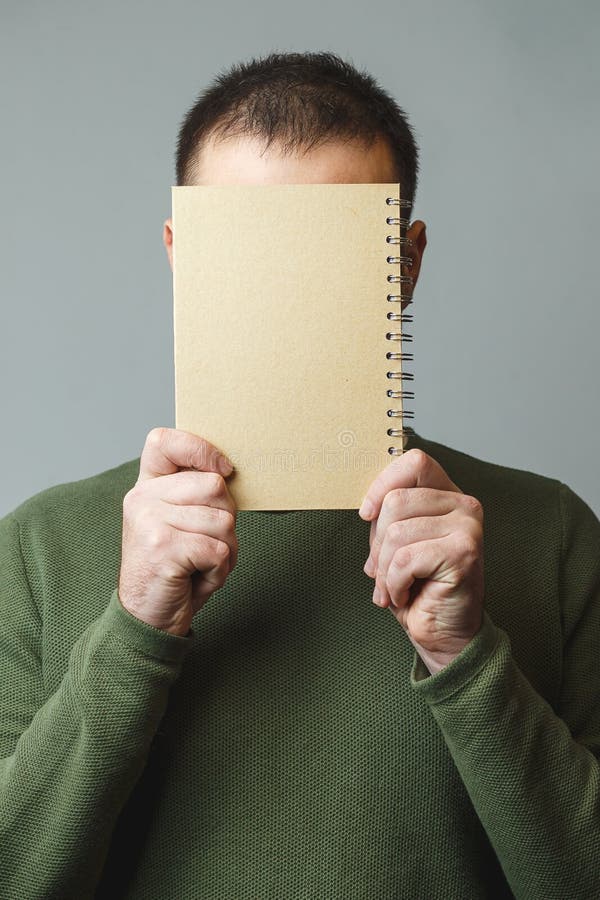 The Man Covers His Face with a Notebook. Vertical Image Stock Photo ...