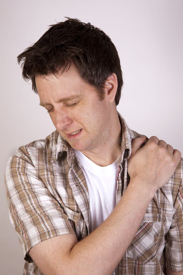Man Cringing from Pain Holding His Shoulder Stock Photo - Image of ...