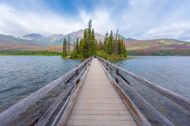 A Man Crossing the Bridge at the Pyramid Island in Alberta, Canada ...